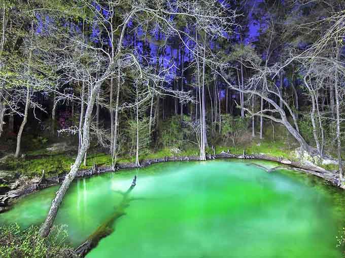 Nature's light show transforms Leon Sinks at twilight, turning emerald waters into a mystical pool that seems to glow from within.