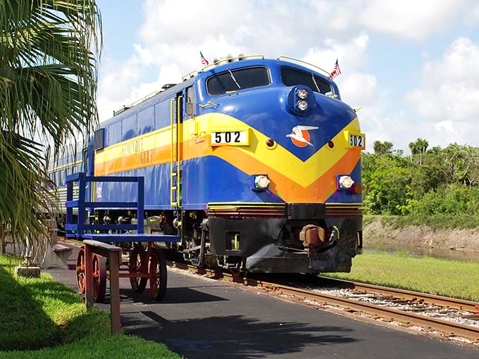 The Seminole Gulf Railway's vintage locomotive stands proudly in Fort Myers, its blue and yellow livery promising an evening of elegant intrigue and culinary delights.