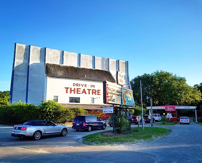 The iconic white facade of the Ocala Drive-In stands like a time machine against the Florida sky, promising an evening of nostalgic movie magic.