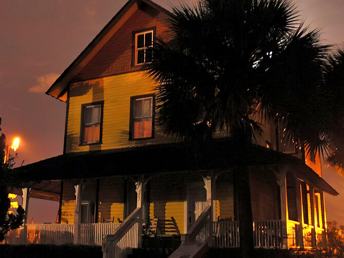 The Riddle House: Bathed in twilight's glow, this sunshine-yellow Victorian beauty stands proudly, its wraparound porch practically begging for ghost stories and sweet tea.