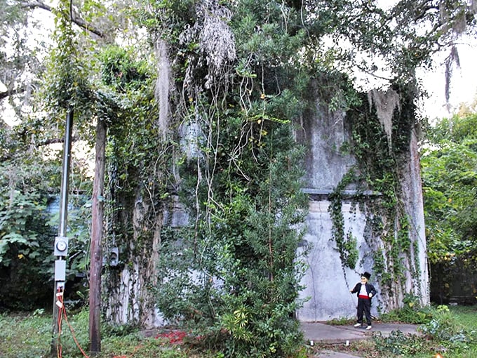 Nature reclaims what man abandoned at the Old Gilchrist County Jail, where vines and moss create a haunting green shroud around weathered concrete walls.