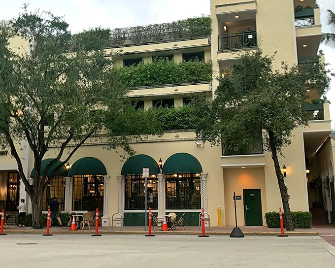 The iconic cream-colored fa&ccedil;ade with signature green awnings stands as a beacon of culinary excellence on Washington Avenue, welcoming seafood enthusiasts for generations.