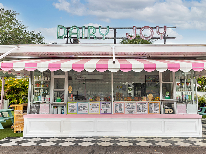 The iconic pink and white awning of Dairy Joy beckons like a sweet mirage in the Florida heat, promising cold comfort and nostalgic bliss to all who approach.
