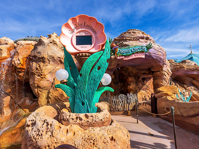 The enchanting entrance to Ariel's Grotto beckons visitors with its giant seashell sign and whimsical seahorse trumpeter. Underwater magic awaits!