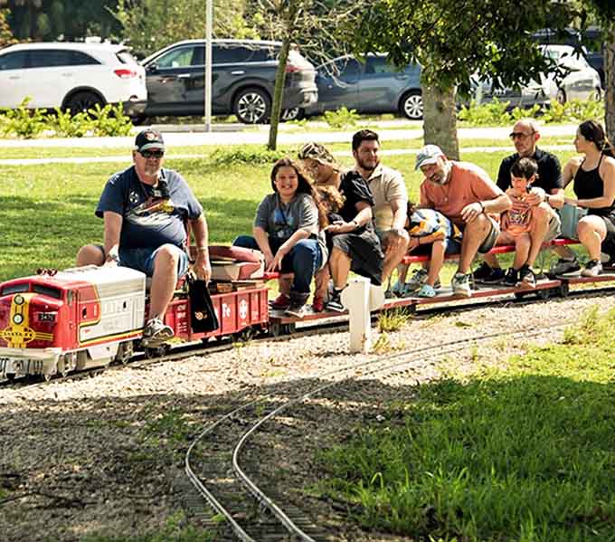 Families squeeze onto miniature train cars, knees up to chins, smiles wider than the Florida sunshine &ndash; pure joy on rails.