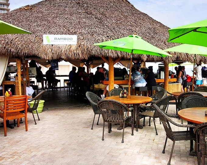 The iconic thatched roof of Bamboo Beach Tiki Bar welcomes visitors with promises of tropical drinks and ocean breezes.