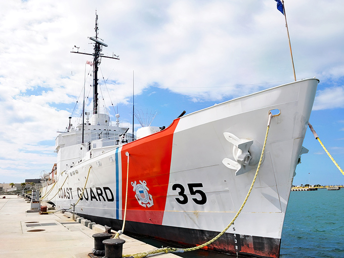 The majestic USCGC Ingham stands proudly at dock, its white hull and orange racing stripe gleaming in the Florida sunshine.