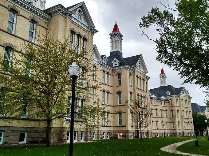 The imposing Victorian-Italianate architecture of the former asylum stands in stark contrast to Michigan's blue skies, its distinctive red-tipped towers reaching skyward like exclamation points.