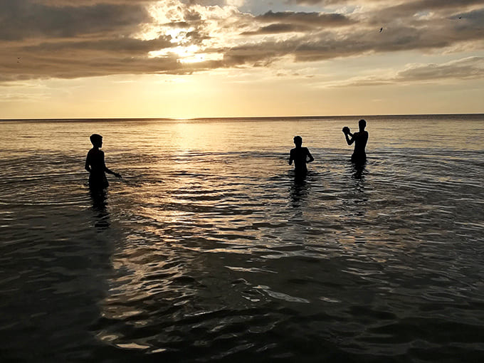 Silhouettes at sunset, proving that the best family photos don't require a photographer, just perfect timing.