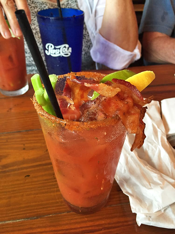 This isn't just a Bloody Mary; it's breakfast in a glass, complete with a bacon strip that's practically begging to be your new profile picture.