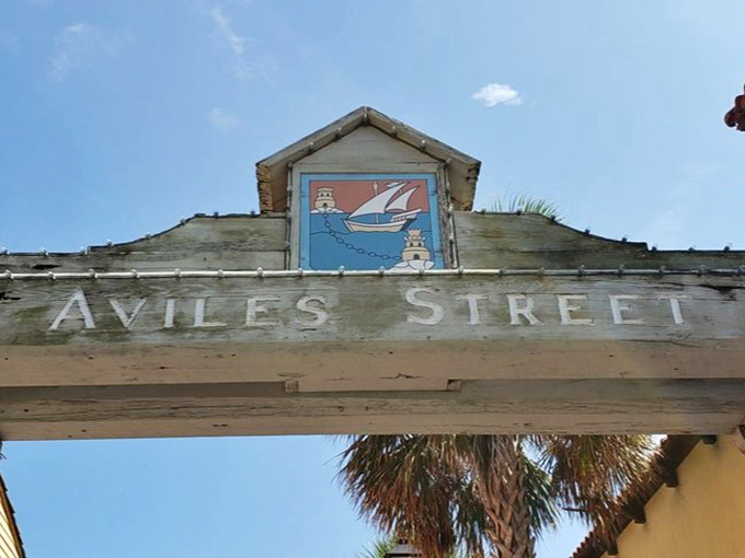 That weathered wooden sign has been photobombing vacation pictures longer than most of us have been alive.
