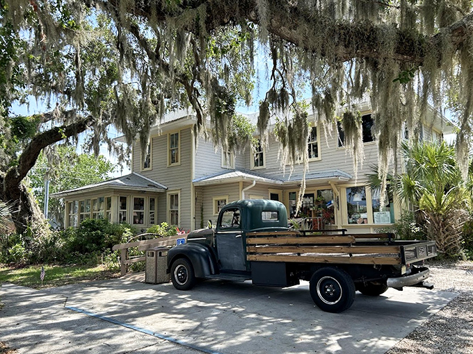 Spanish moss drapes dramatically over this historic home-turned-market, while a classic pickup truck completes the timeless Southern scene.