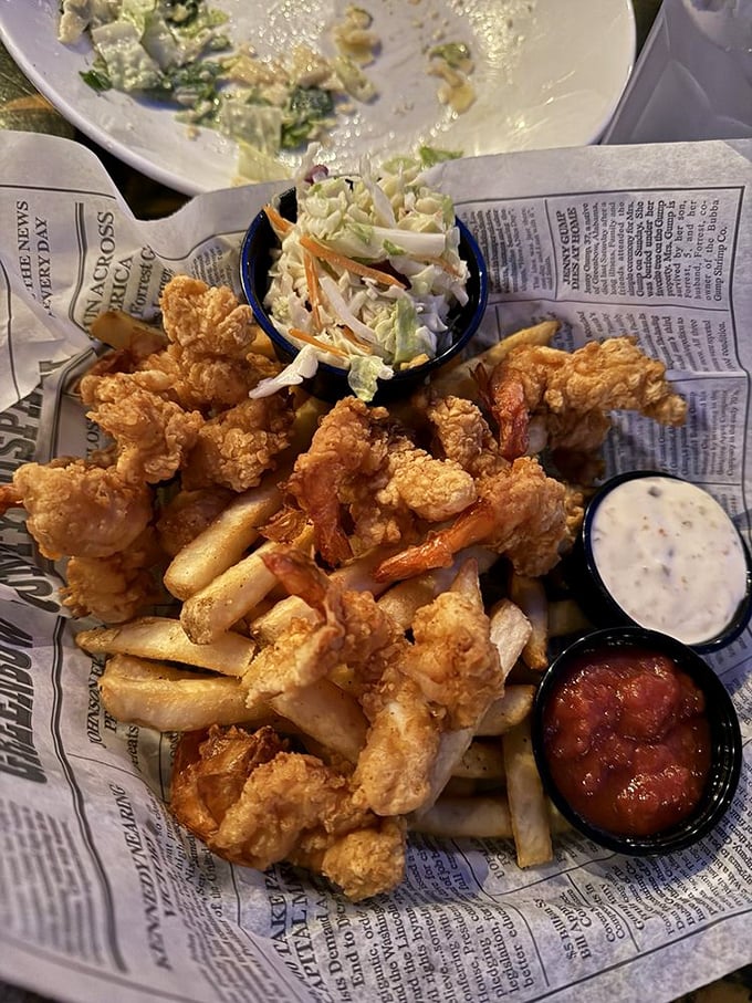 Crispy fried shrimp arrive on a bed of newspaper, accompanied by tangy dipping sauces and fresh coleslaw, a seafood lover's dream.