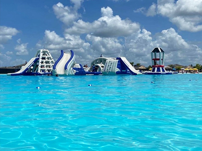 Inflatable Water Park Course A floating playground where adults rediscover their inner child and children discover their parents' surprising lack of coordination.