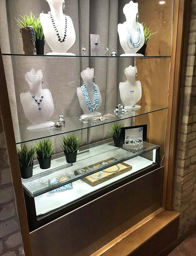 Delicate blue-hued necklaces catch the light in elegant glass cases – artisan craftsmanship that adds a touch of luxury to the historic surroundings.