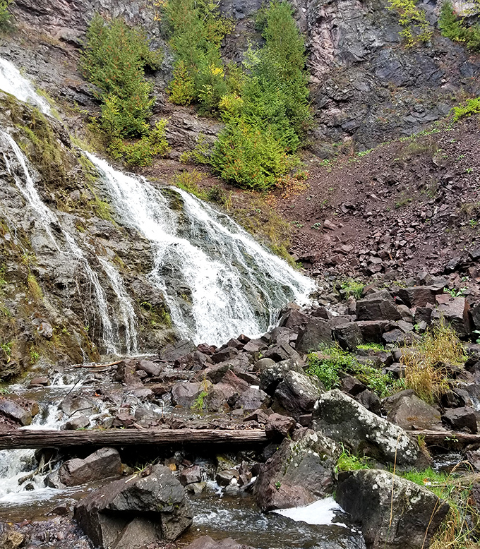 Manganese Falls cascades dramatically through ancient rock, creating a misty microclimate where ferns thrive in rocky crevices.