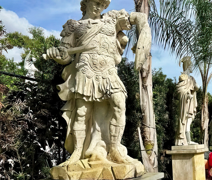 Imposing Roman-style statues stand guard near the nativity, creating an unexpected art history lesson in the middle of suburban Florida.