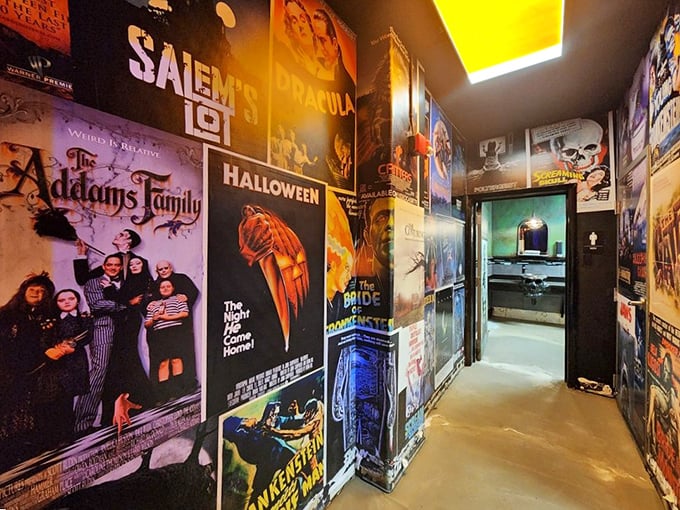 The hallway to the restrooms features classic horror movie posters, setting the mood for the themed facilities beyond.