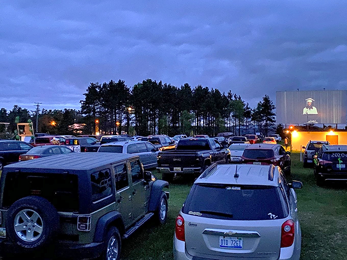 Movie magic illuminates the night as families nestle into their vehicles, creating private theaters under the collective sky.