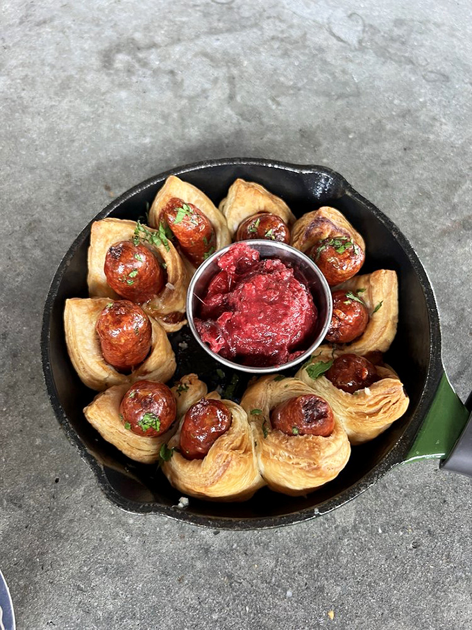 Childhood nostalgia gets a gourmet upgrade with these golden-brown pastry-wrapped sausages, served with a cranberry dipping sauce that's surprisingly sophisticated.