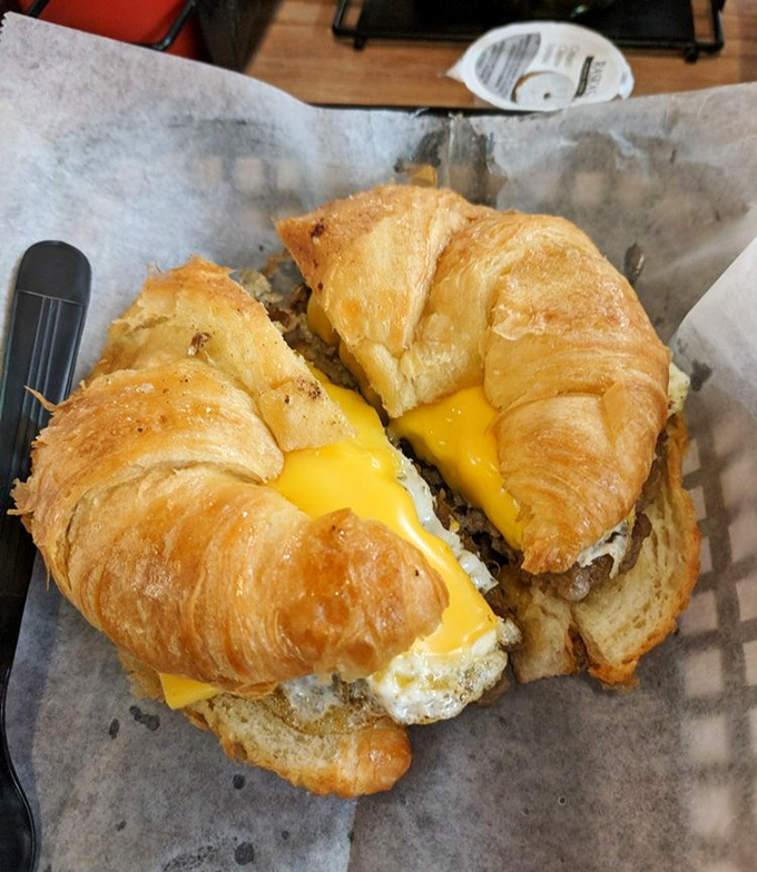 Breakfast perfection on a croissant &ndash; golden, flaky layers embracing eggs, sausage and cheese like old friends reuniting.