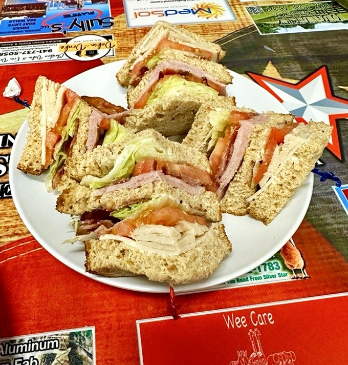 The club sandwich stands tall and proud, a skyscraper of freshness that requires both hands and possibly a strategy meeting before tackling.