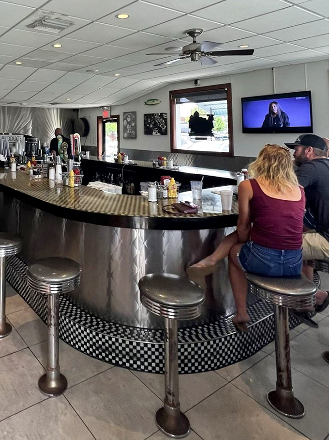 The counter offers front-row seats to the kitchen ballet, where coffee flows freely and regulars exchange morning news.