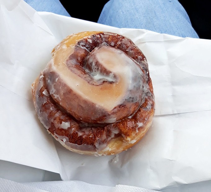 The cinnamon roll spirals hypnotically, its cream cheese glaze melting into every warm, spice-filled crevice like a sweet avalanche.