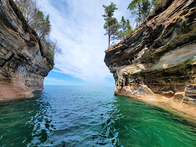 Narrow passages between towering cliffs create nature's hallways, where kayakers experience the intimate whispers of water against ancient stone.