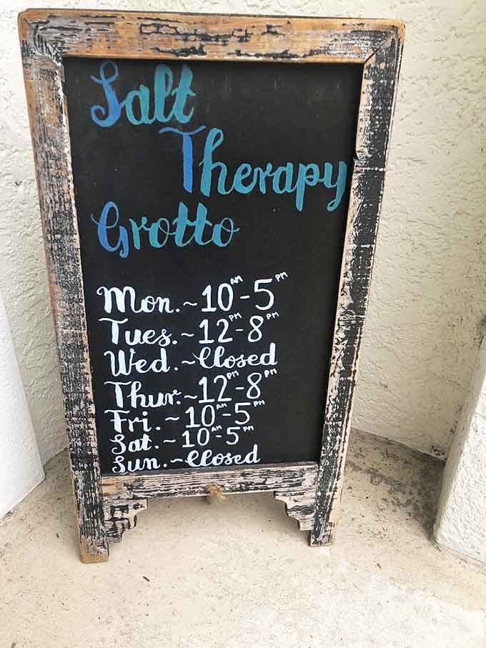 Operating hours posted on a rustic chalkboard, because even transcendental wellness experiences must bow to the constraints of time.