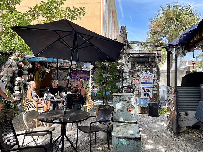 Beach chairs and boat parts create impromptu conversation nooks where strangers become friends over cold drinks and tall tales.