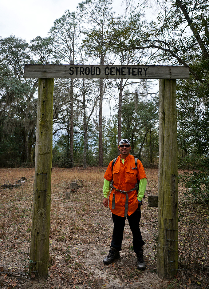 A visitor pauses beneath the cemetery entrance, where history waits patiently for those curious enough to listen.