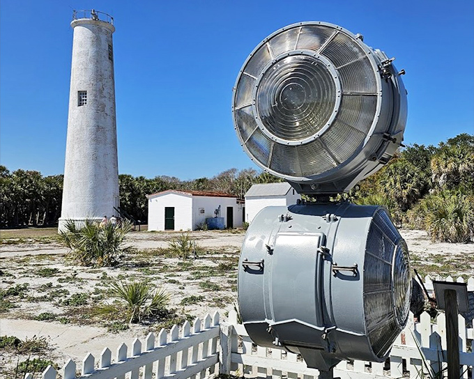 Egmont Key's white lighthouse tower rises from an island paradise, surrounded by pristine beaches and the turquoise waters of Florida's Gulf Coast.