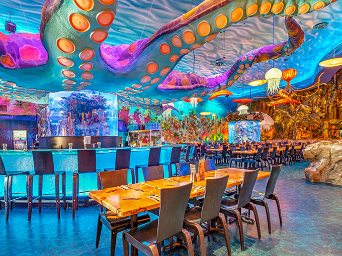 T-Rex Cafe's underwater section features glowing blue aquariums that complement the prehistoric theme. Those tentacles on the ceiling add whimsical underwater drama!