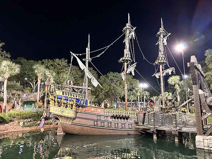 The nighttime lighting transforms this pirate scene into something magical, like Disneyland met a treasure map and had a baby.
