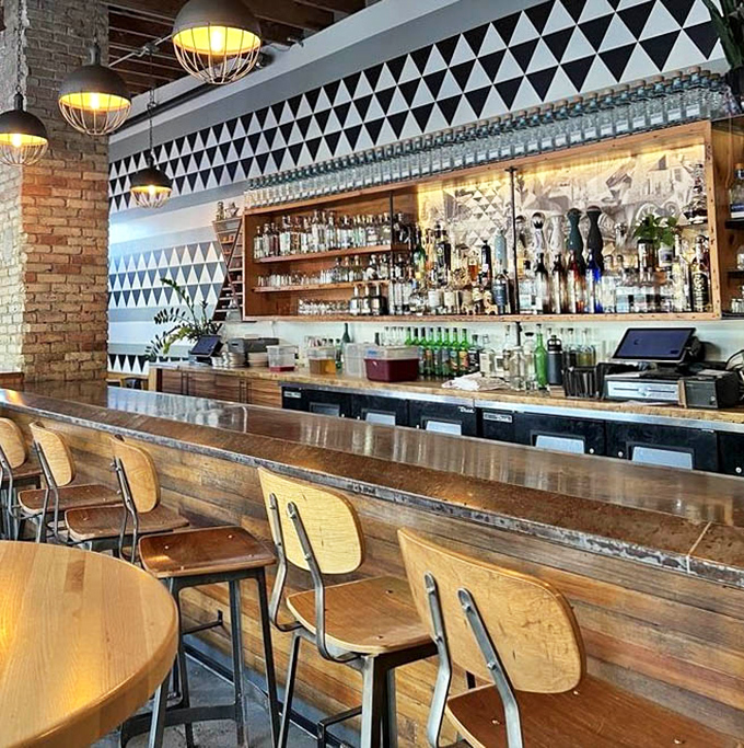 Behind the geometric-patterned bar wall, bottles stand at attention like soldiers guarding the secret to perfect margaritas.