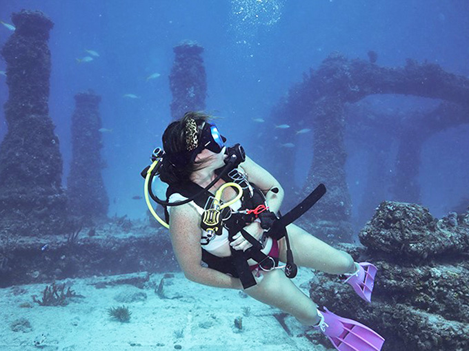 A diver examines the elaborate underwater structures, where every surface has become a canvas for nature's artistic touch.