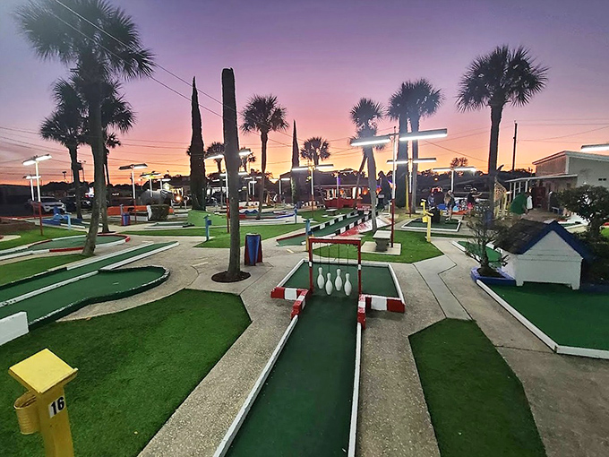 As twilight descends, Goofy Golf transforms into a magical landscape where palm trees frame the colorful course against a painted sky.
