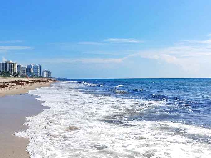 Waves kiss the shoreline in an endless romance, leaving lacy foam trails that disappear like whispered secrets between lovers.