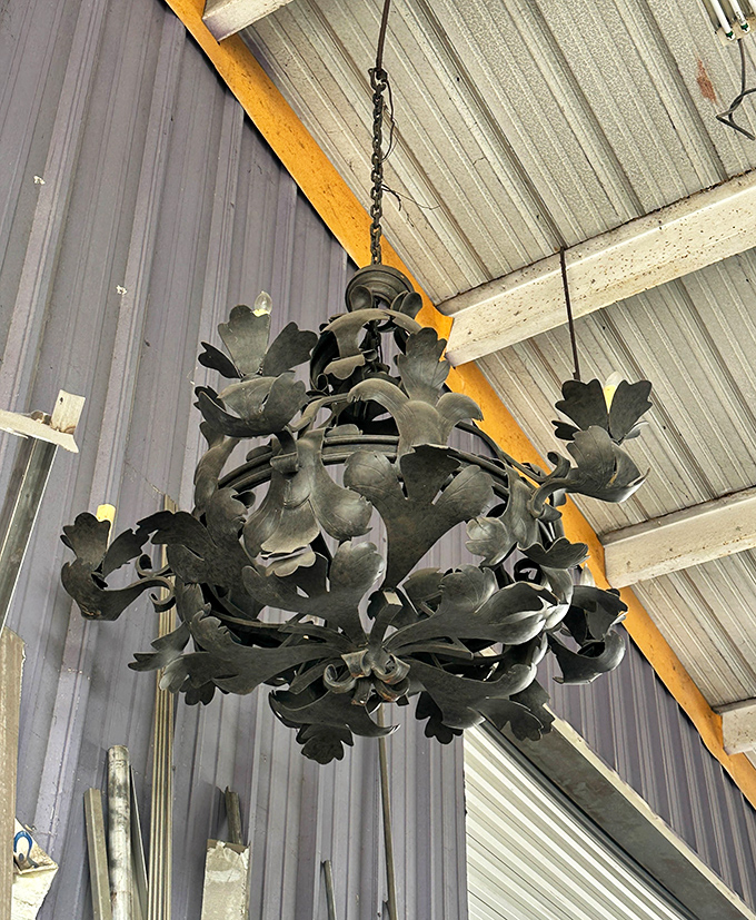 This metal chandelier blooms overhead like a flower made of shadow and light, industrial materials transformed into organic elegance.