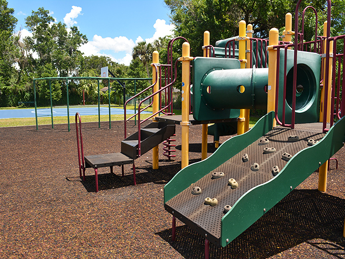 Midway Park's colorful playground equipment promises adventure for little explorers while parents enjoy the lakeside breeze nearby.