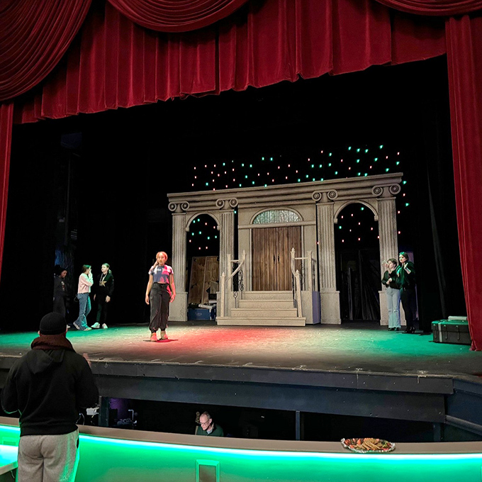 Rehearsals transform the stage into another world, as actors bring characters to life under the glow of professional lighting.