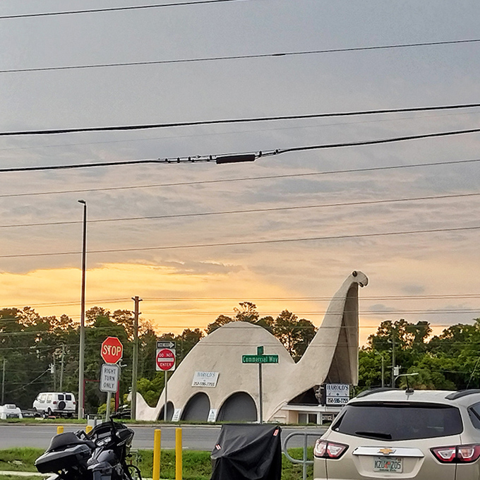 As sunset approaches, the dinosaur's silhouette takes on a magical quality against the fading light of a Florida evening.