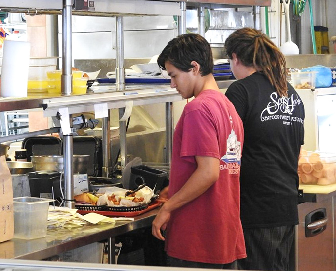 The unsung heroes of Safe Harbor work their seafood magic, transforming the morning's catch into the afternoon's memories.