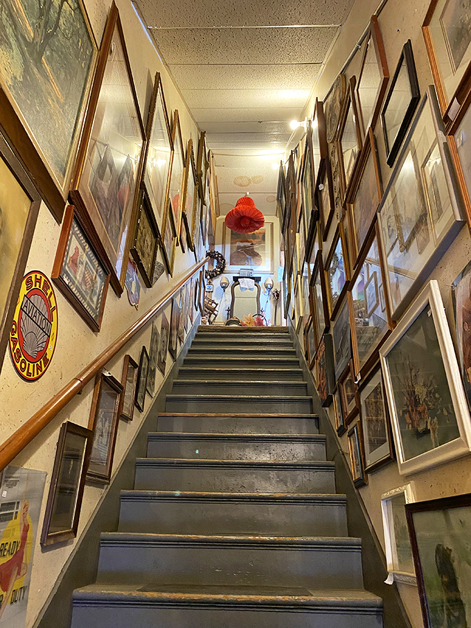 The staircase gallery creates an art-lined journey to the upper floor, with frames so densely packed they become a collage of collective memory.