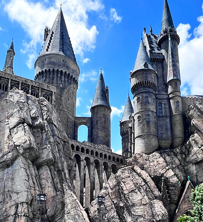 Hogwarts Castle towers majestically against a perfect blue sky, its turrets and battlements promising adventures beyond imagination.