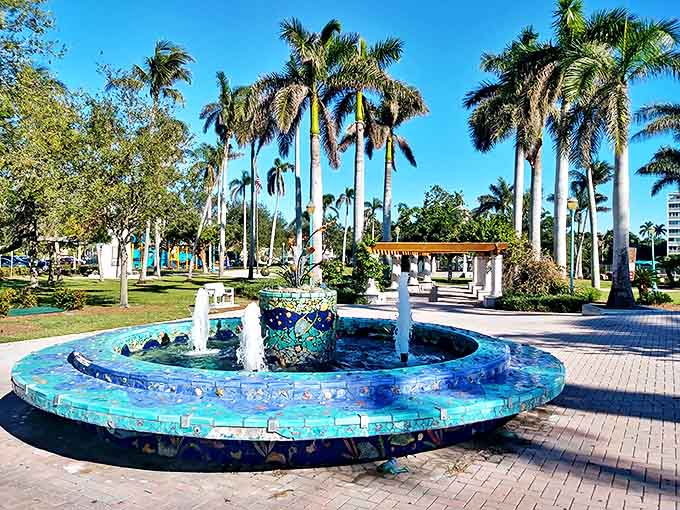 A mosaic fountain sparkles like the Intracoastal beyond, creating a peaceful oasis amid royal palms.