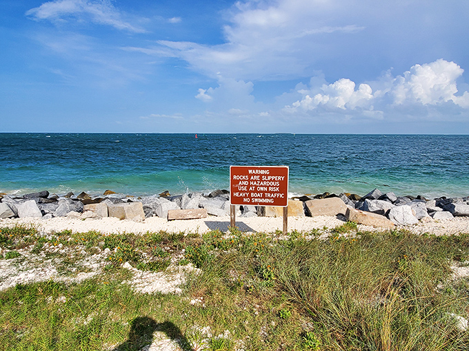 Warning signage: Nature's fine print – where the ocean politely informs visitors that beauty sometimes comes with rocky conditions.