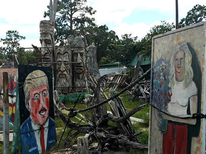 Wooden giants stand sentinel among colorful paintings, creating a surreal landscape where different art forms converse with each other.