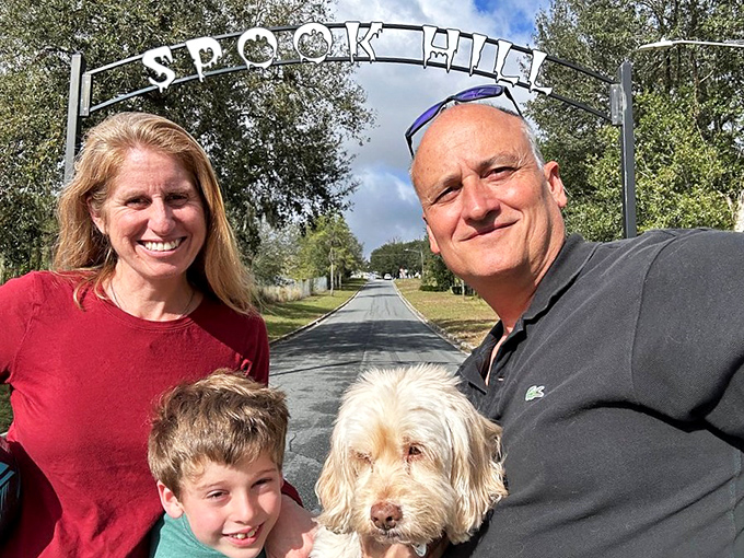 Families with their furry friend gather at the Spook Hill sign &ndash; this attraction has been creating multi-generational memories for decades.